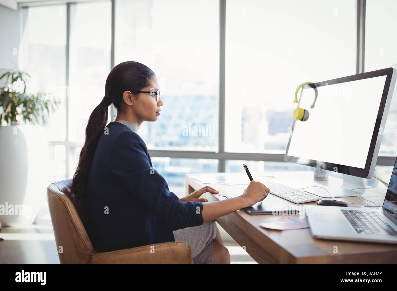 Attentive graphic designer working at desk in office Stock Photo - Alamy