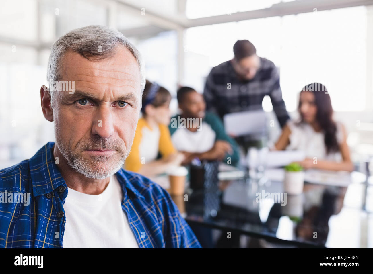 Portrait of serious businessman at creative office Stock Photo - Alamy