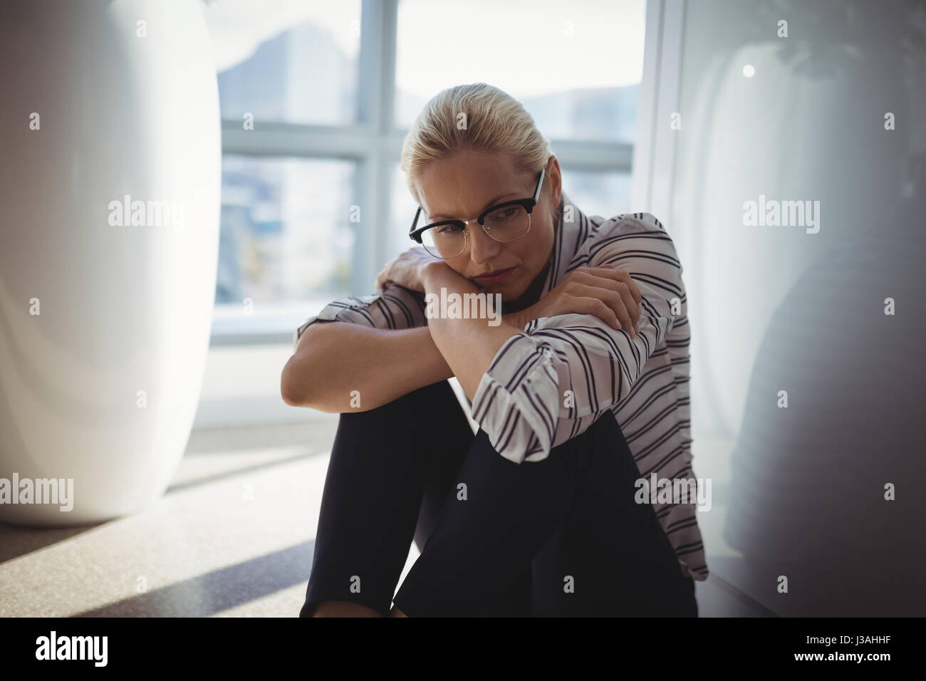 Sad executive sitting on floor in office Stock Photo - Alamy