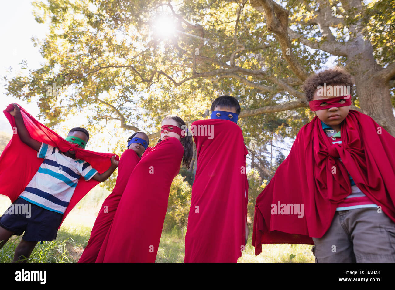 Low angle view of friends enjoying while wearing superhero costume at ...