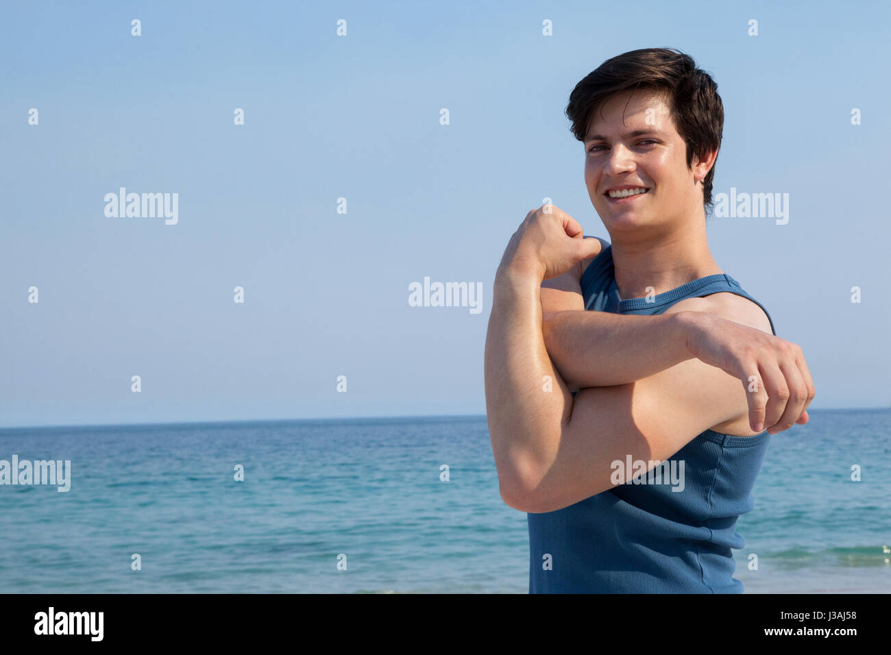 Portrait of smiling man stretching his hand on beach Stock Photo - Alamy