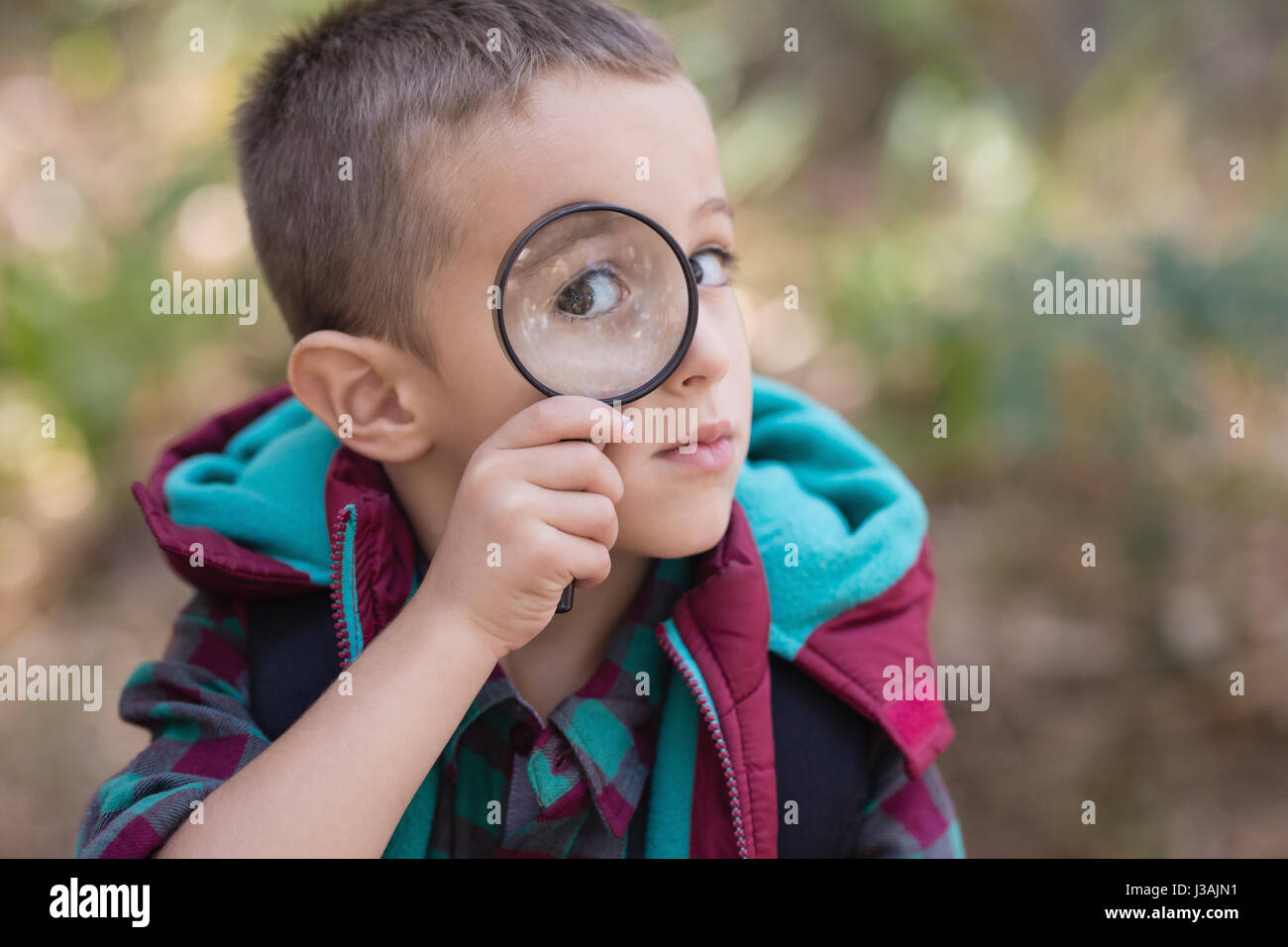 Portrait of little boy looking through magnifying glass Stock Photo - Alamy