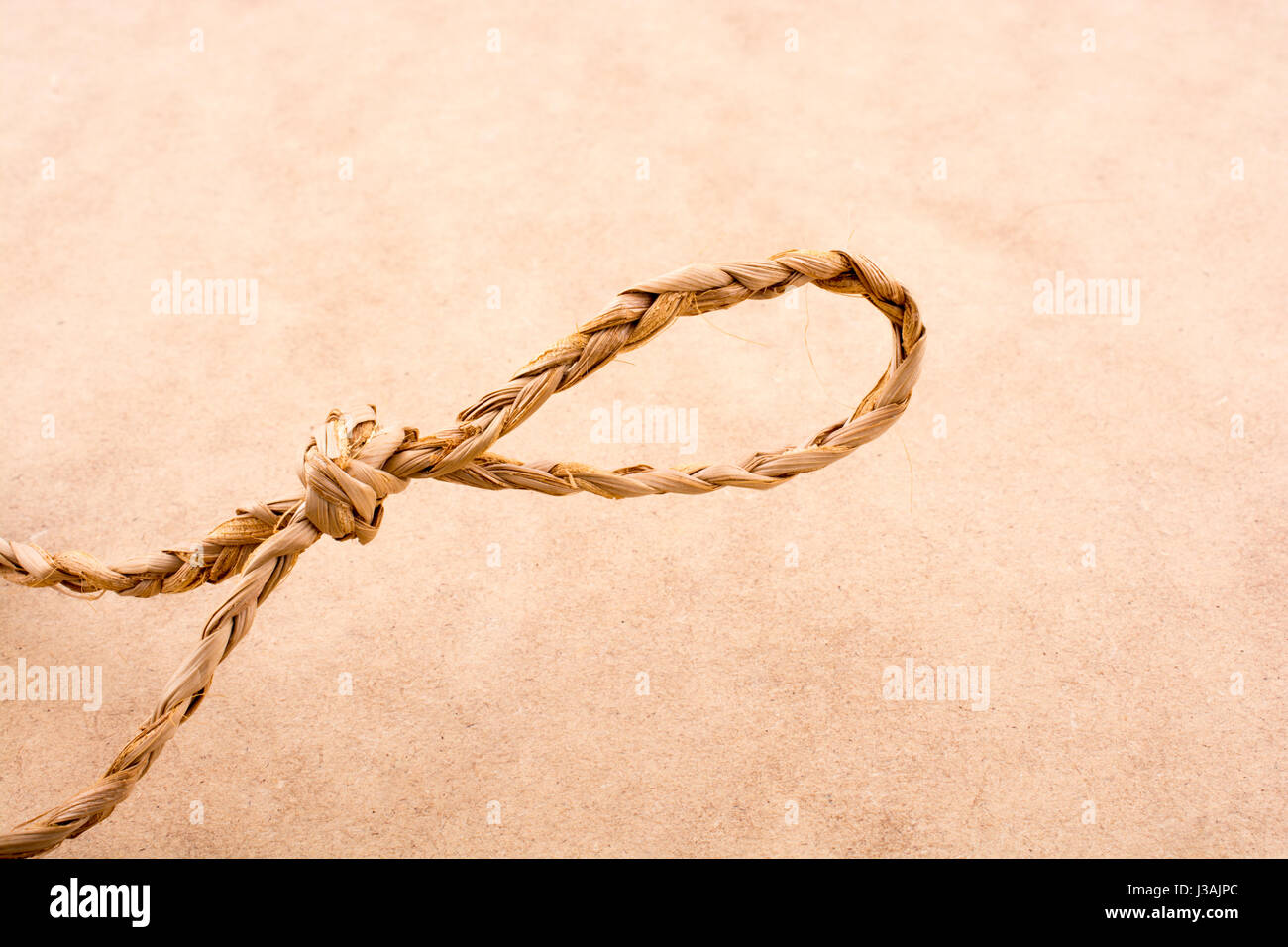 Straw tied as knot on a light color background Stock Photo - Alamy