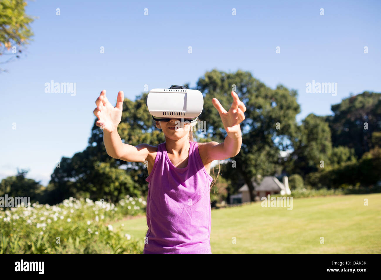 Playful girl using vr headset in the park Stock Photo - Alamy