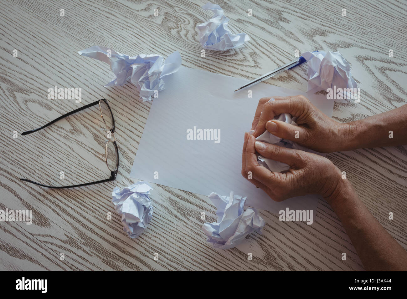 Cropped hands of businesswoman crumpling papers on desk in office Stock ...