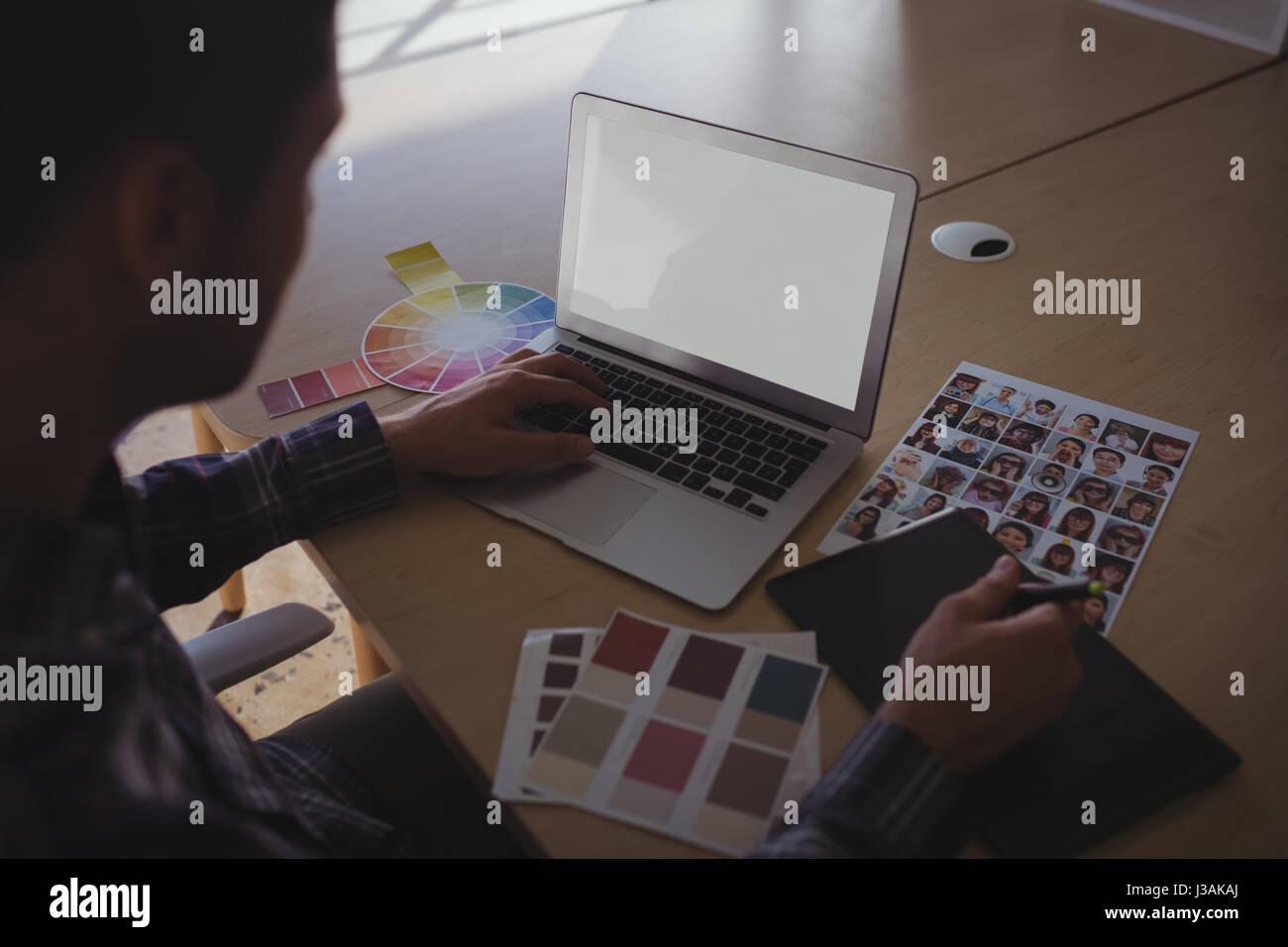 High angle view of creative businessman using digitizer and laptop on ...