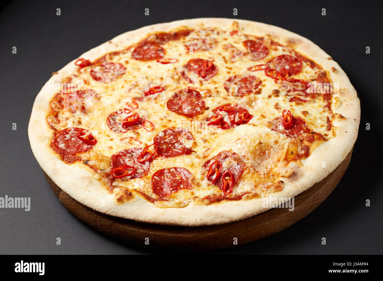 Hot pizza Diablo on a rustic wooden table. Italian food Stock Photo - Alamy