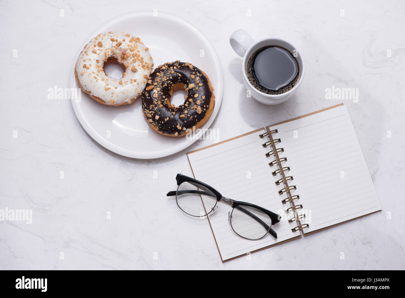 Working desk with dessert and coffee. Cake donuts with a cup of ...