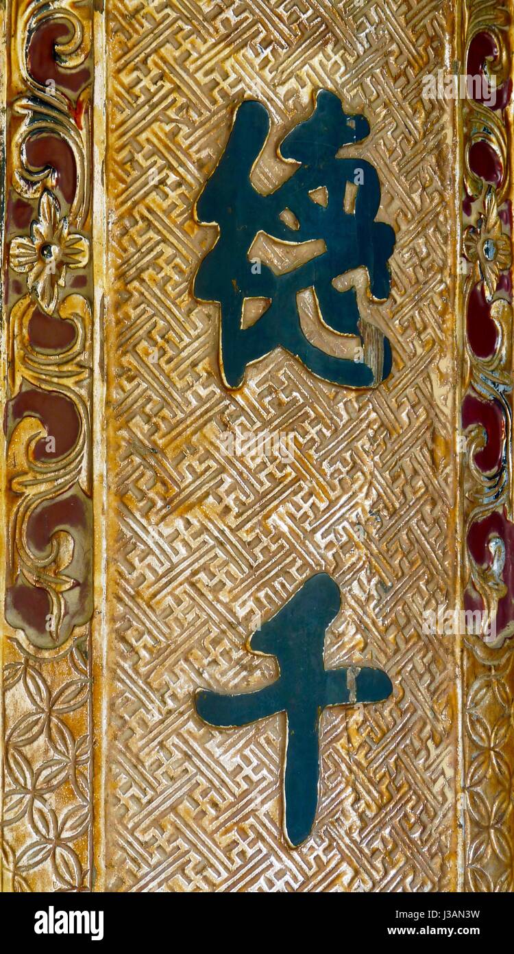 Close up of faded , textured golden temple panel with black Vietnamese ...