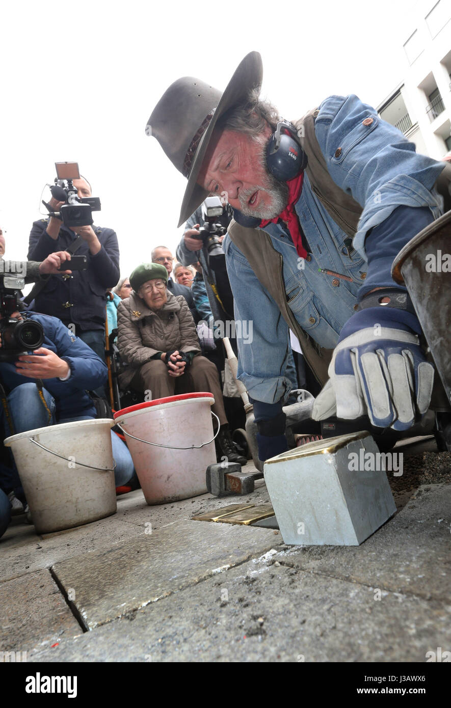 Artist Gunter Demnig sets two so-called Stolpersteine - cobblestone ...