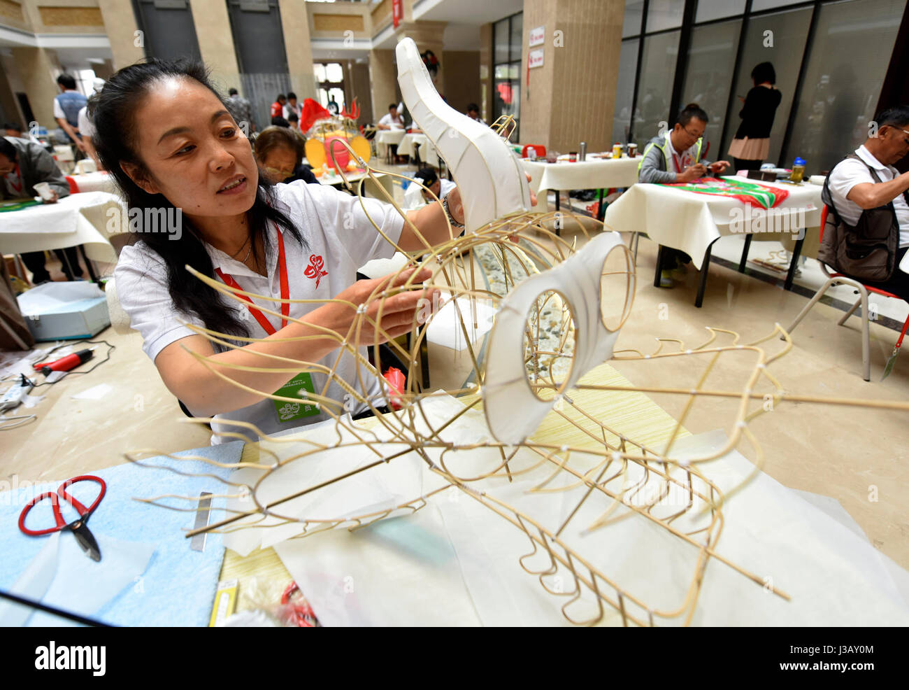 Langfang, China's Hebei Province. 4th May, 2017. A woman makes a kite ...