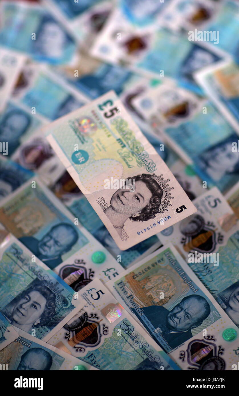 Swansea, UK. 4th May, 2017. An old £5 note resting on a bed of new ones ...