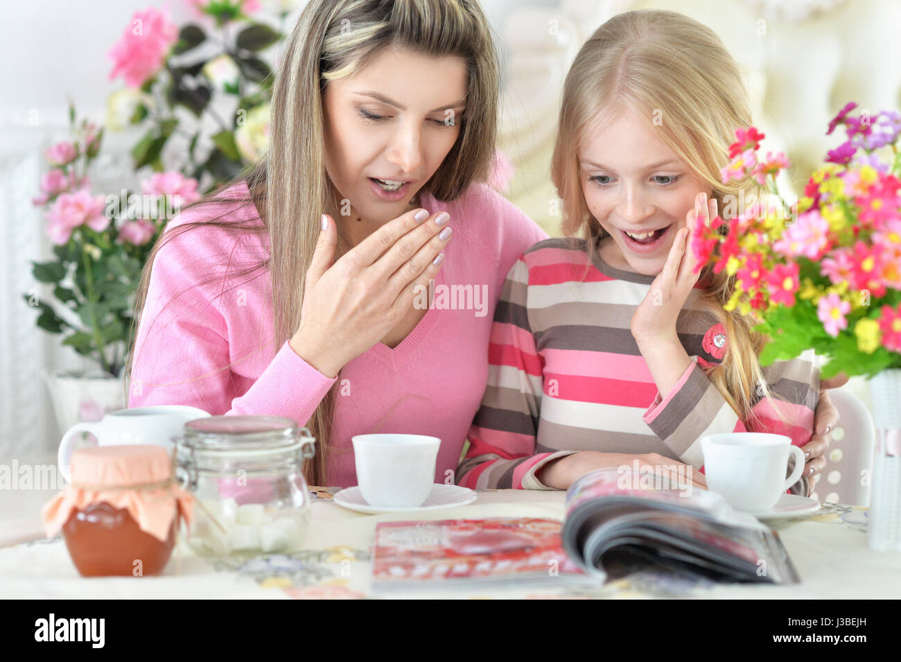 Mom and daughter watch the magazine Stock Photo - Alamy
