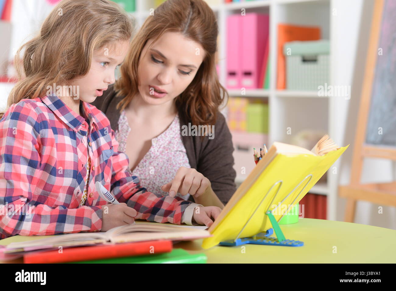 Mom and daughter doing lessons Stock Photo - Alamy