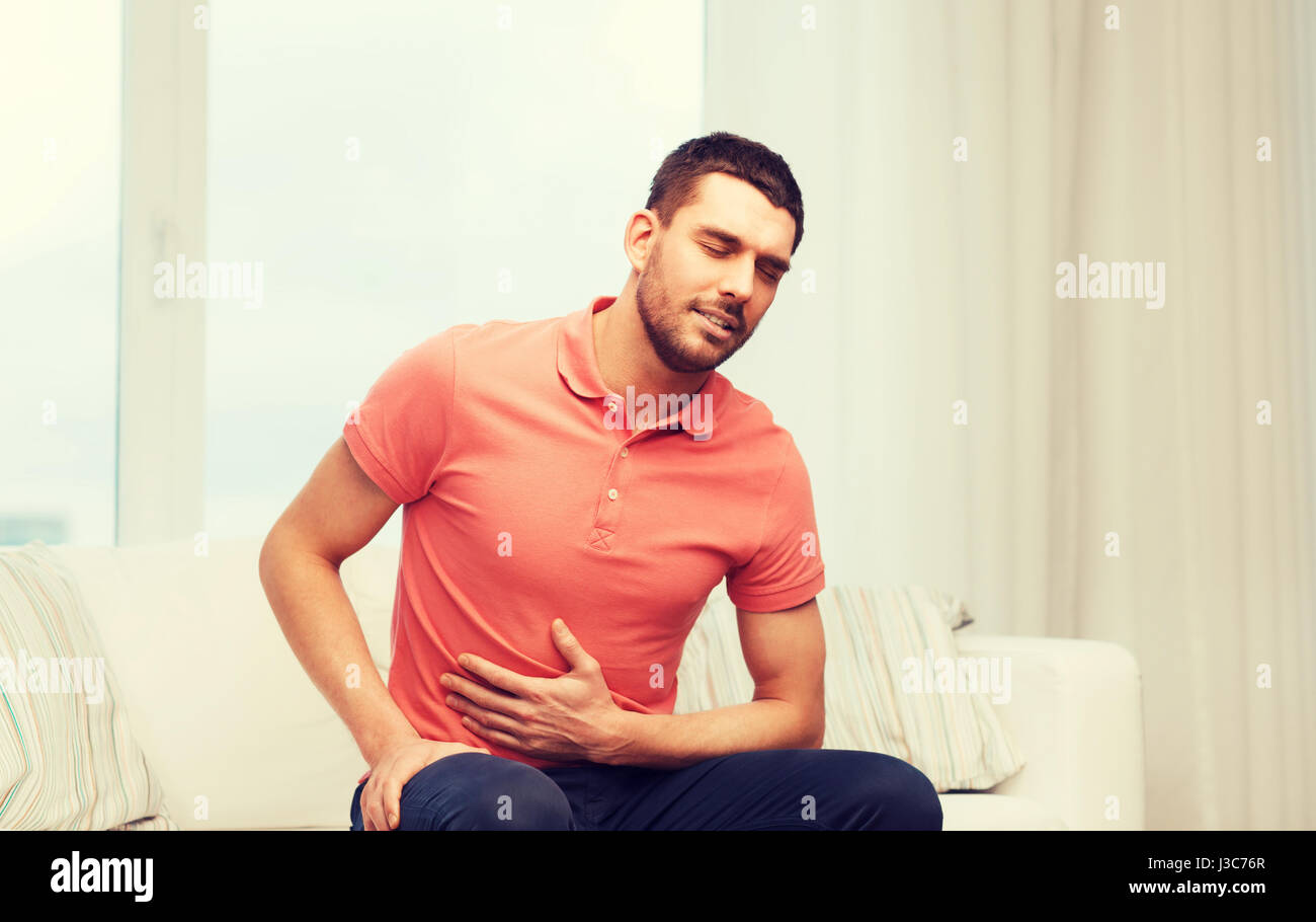unhappy man suffering from stomach ache at home Stock Photo - Alamy