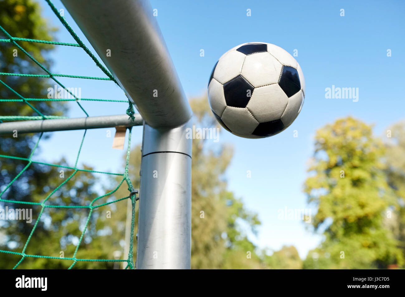 soccer ball flying into football goal net on field Stock Photo - Alamy