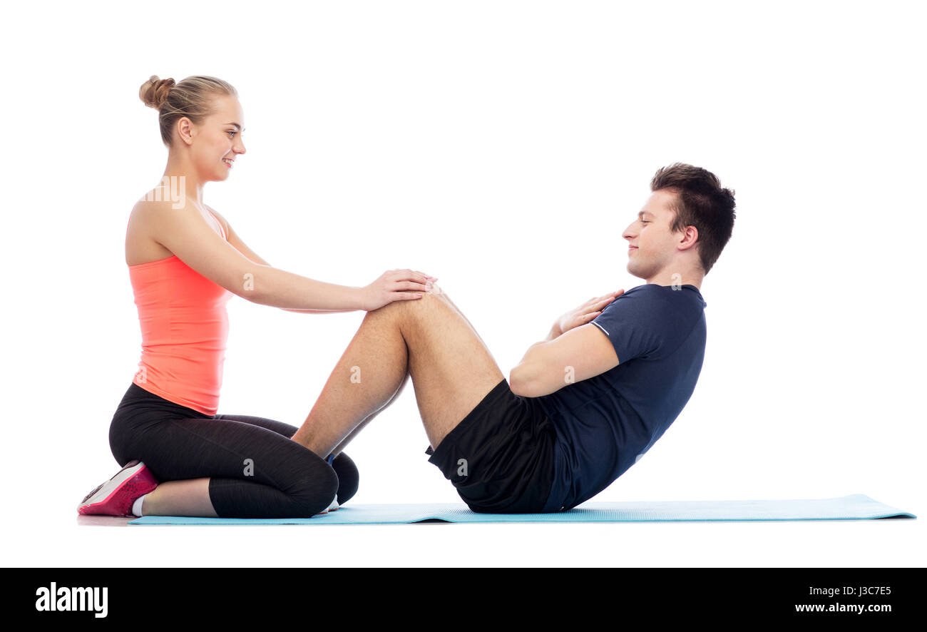 happy sportive man and woman doing sit-ups Stock Photo - Alamy