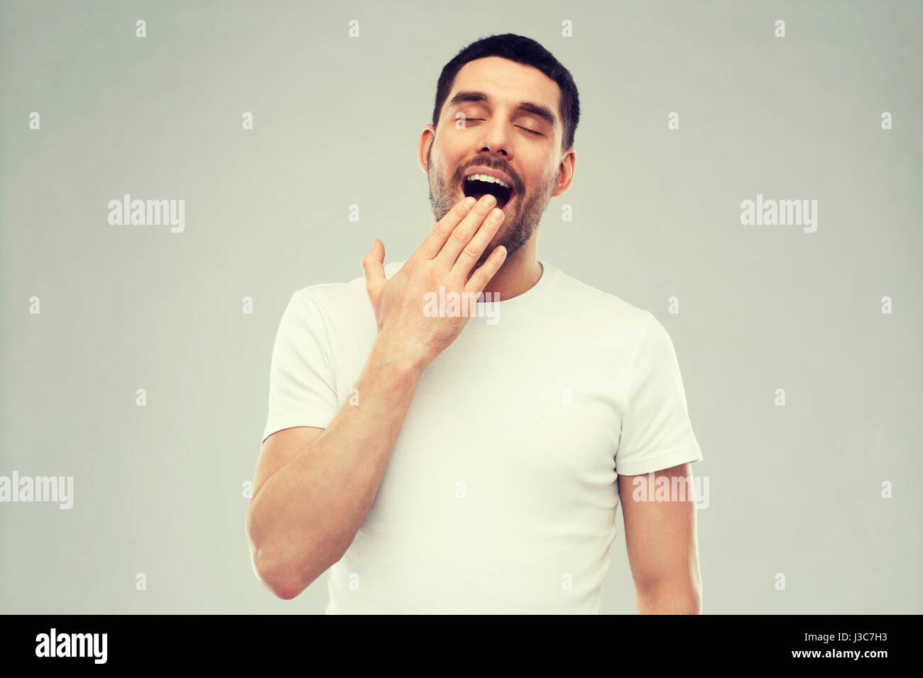 yawning man over gray background Stock Photo - Alamy