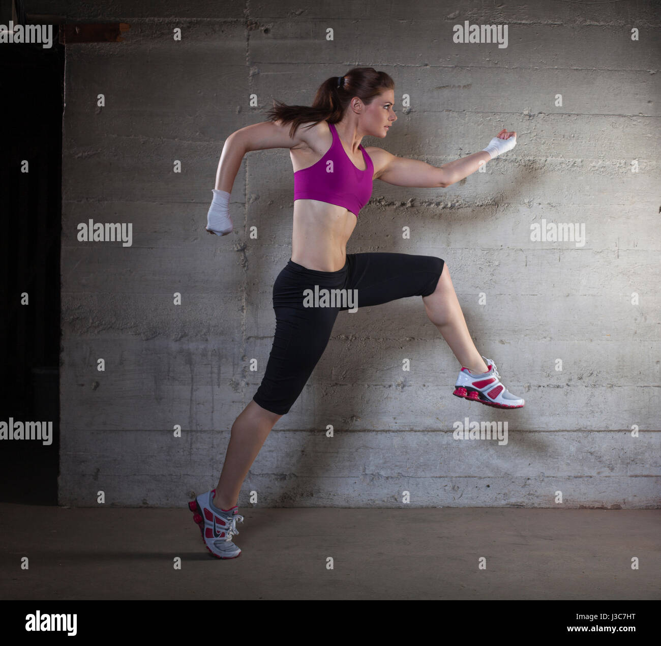 Strong fit athletic woman kicking and throwing punches. Image taken ...