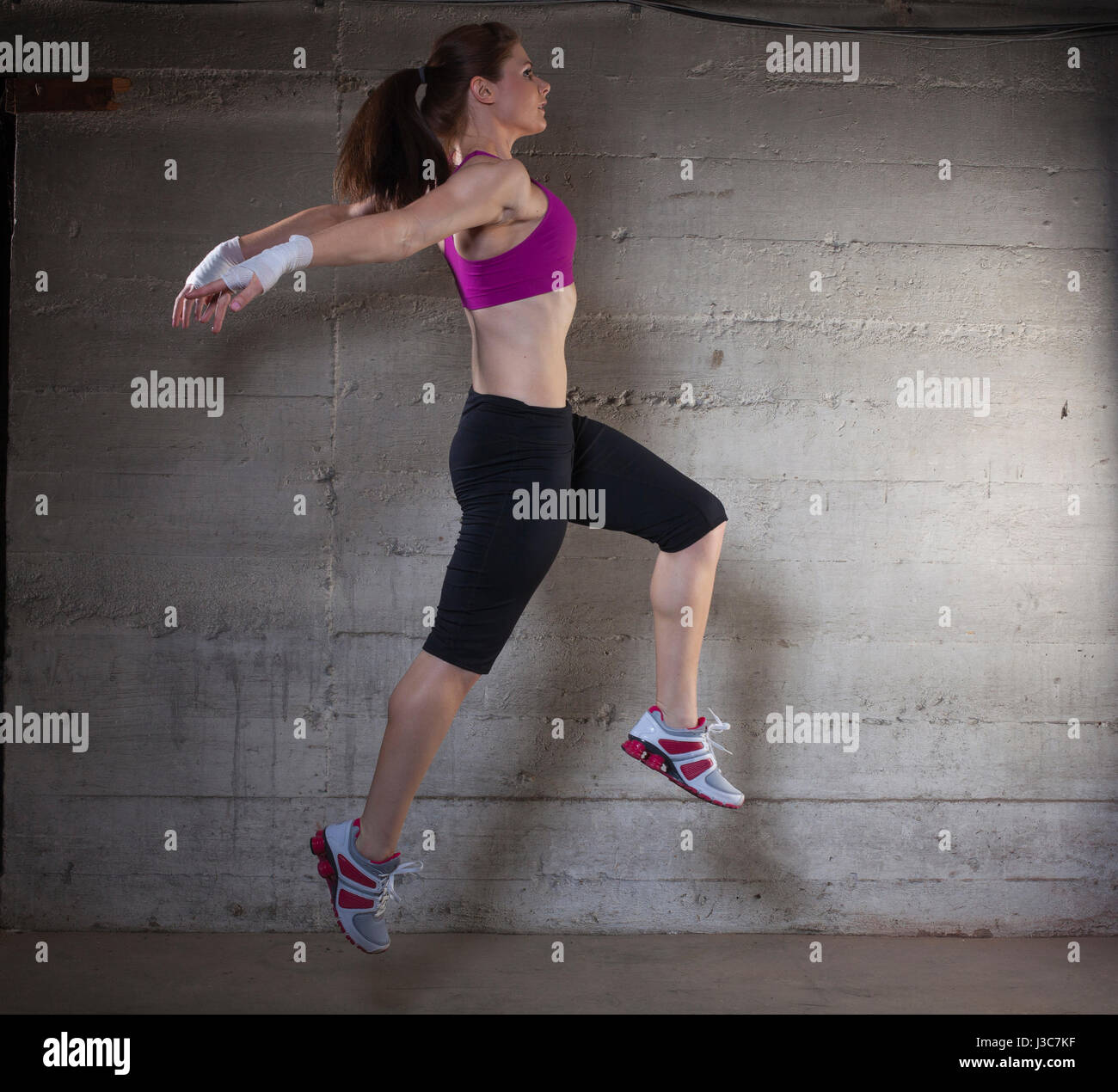 Strong fit athletic woman kicking and throwing punches. Image taken ...