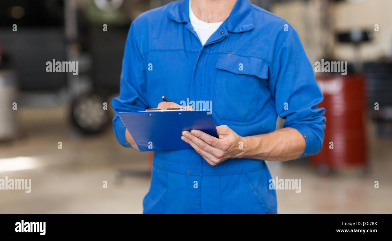 mechanic man with clipboard at car workshop Stock Photo - Alamy