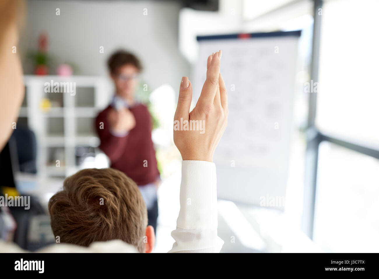 woman raising hand at presentation in office Stock Photo - Alamy