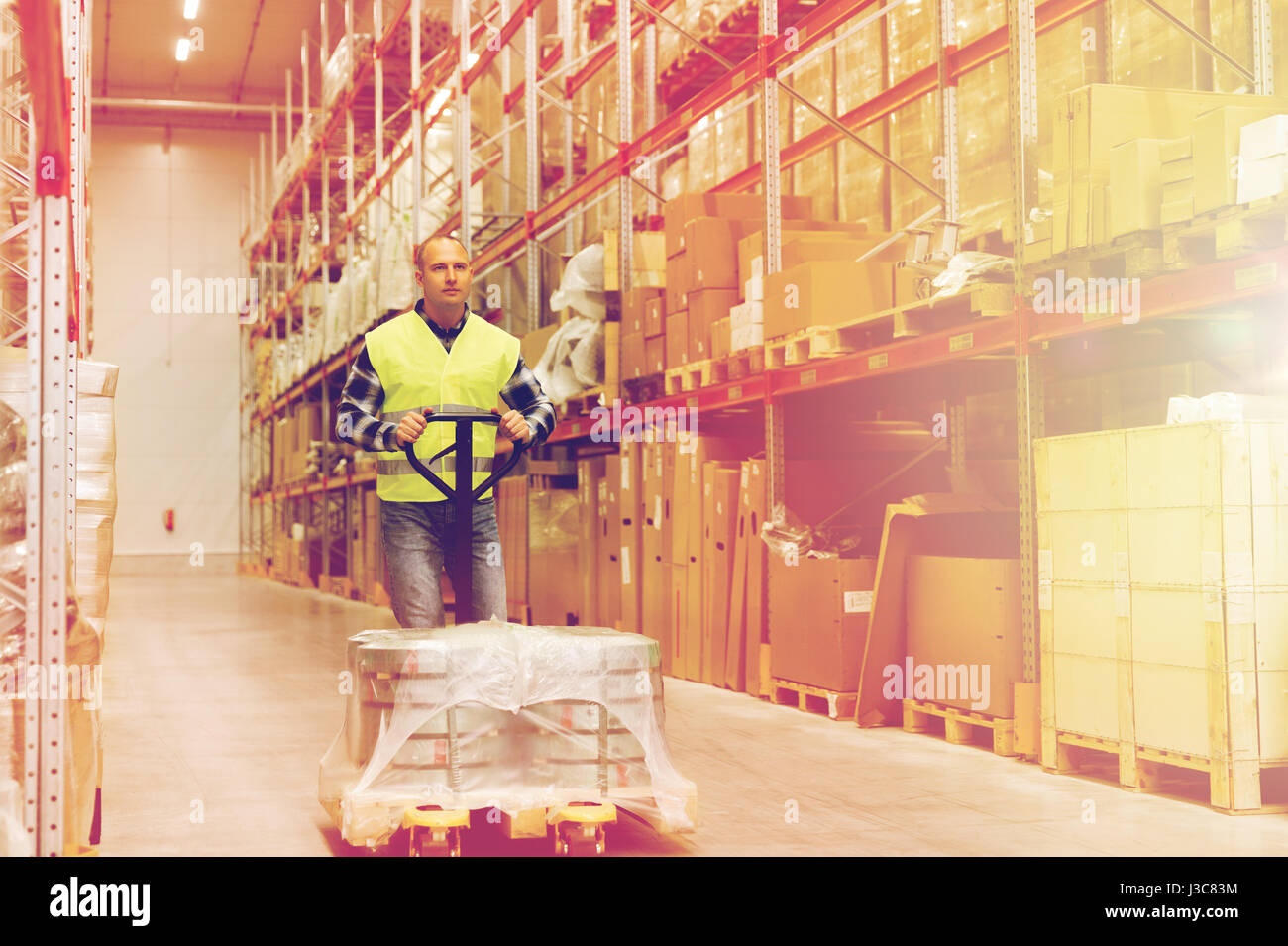 man carrying loader with goods at warehouse Stock Photo - Alamy
