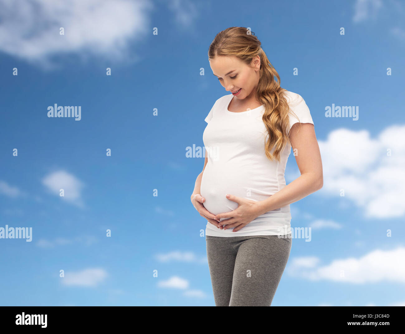 happy pregnant woman touching her big belly Stock Photo - Alamy