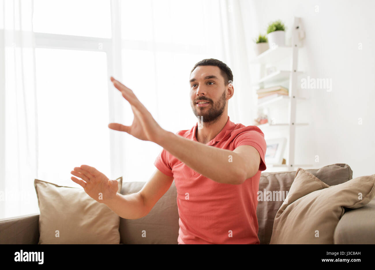 happy man touching something imaginary at home Stock Photo - Alamy
