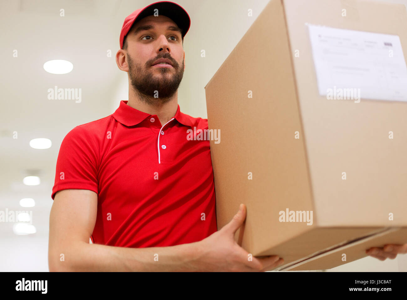 delivery man with parcel box in corridor Stock Photo - Alamy