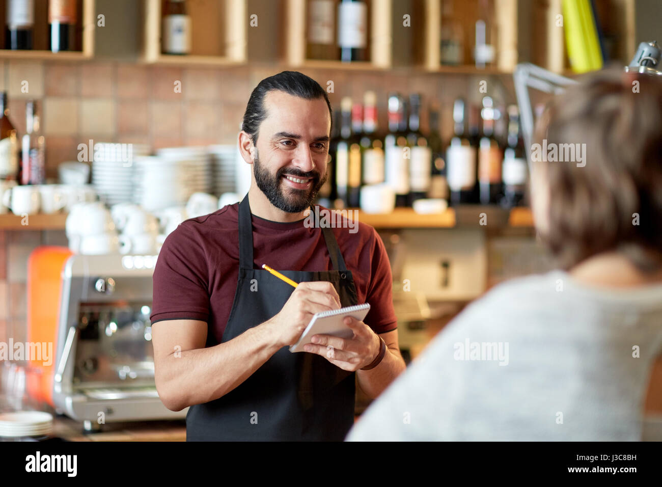 man or waiter serving customer at bar Stock Photo - Alamy
