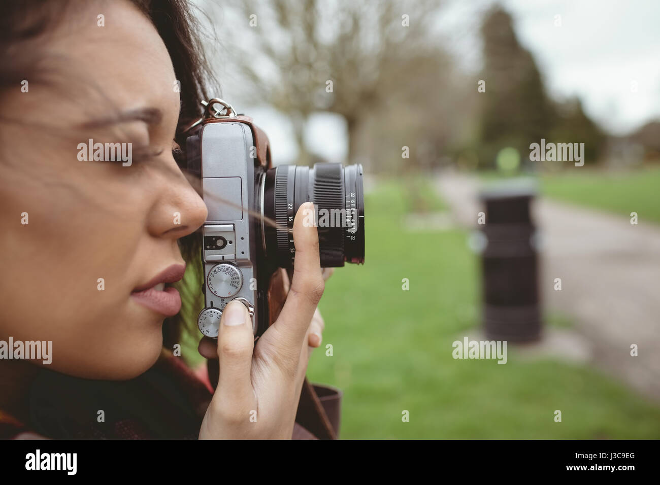 Woman taking photo from digital camera in park Stock Photo - Alamy