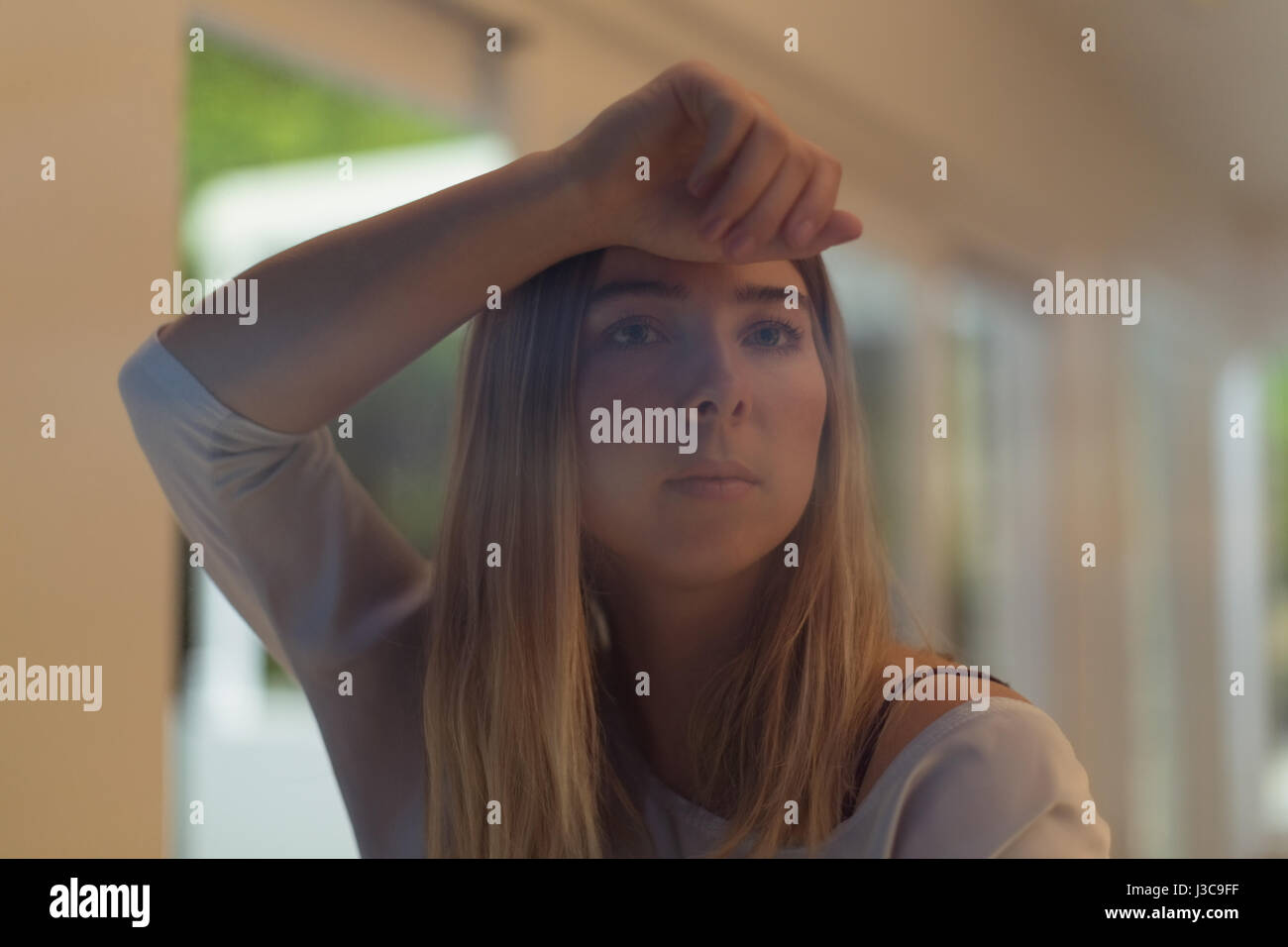 Thoughtful woman leaning on window at home Stock Photo - Alamy