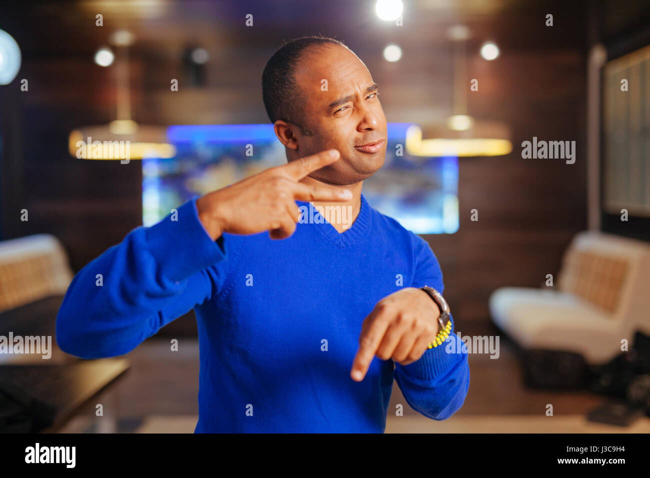 Portrait of a young man smiling showing hand peace sign Stock Photo - Alamy