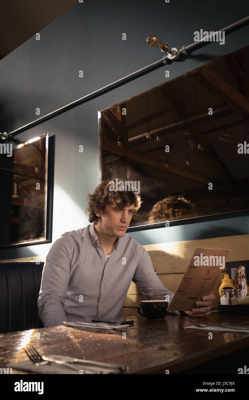 Man looking at menu card in restaurant Stock Photo - Alamy