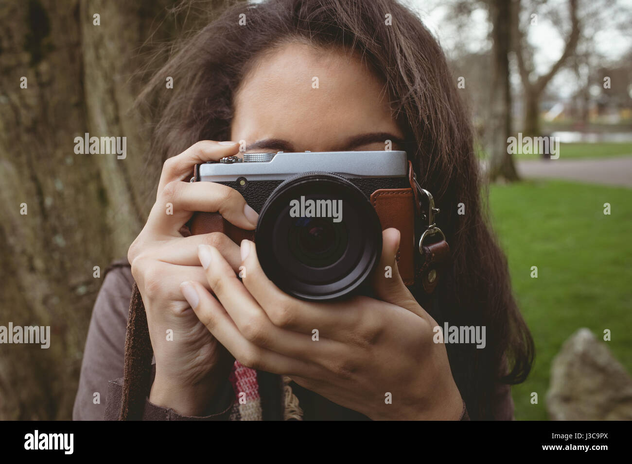 Close-up of woman taking photo from digital camera in park Stock Photo ...