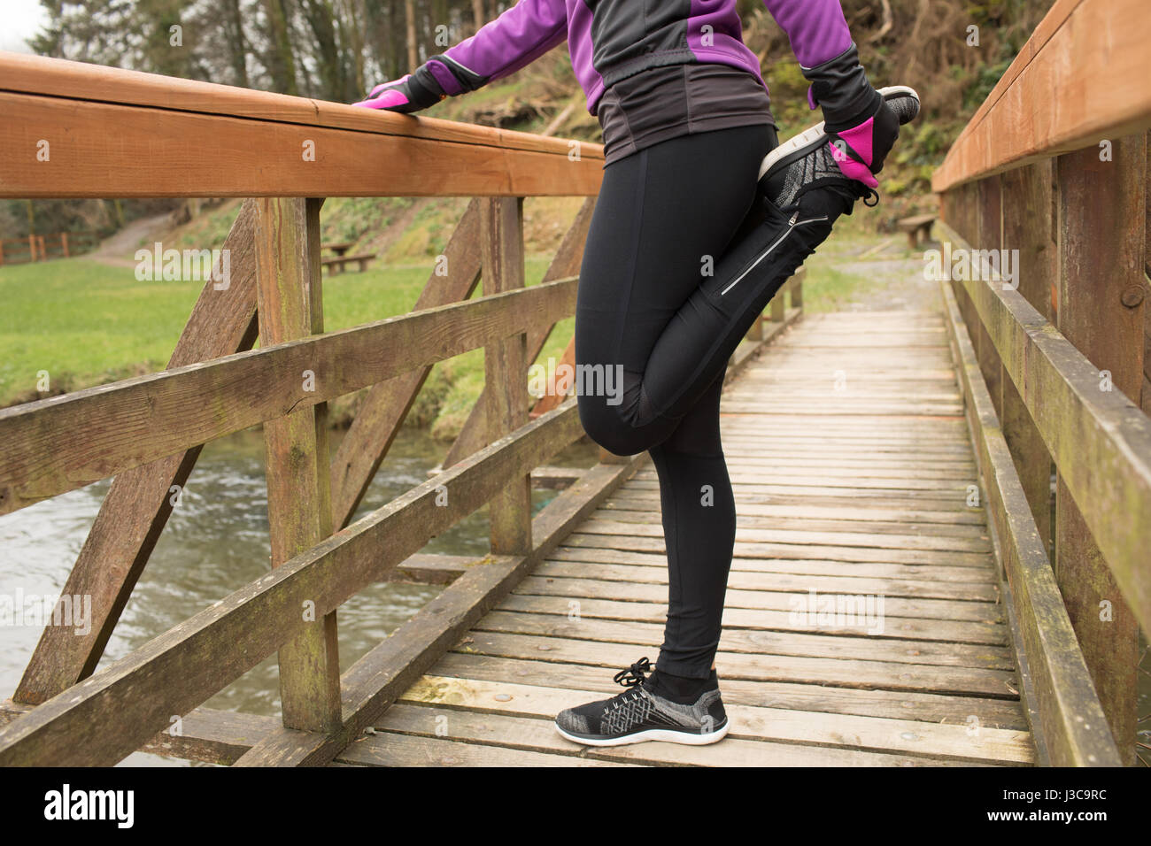 Mid section of woman performing stretching exercise on the bridge in ...