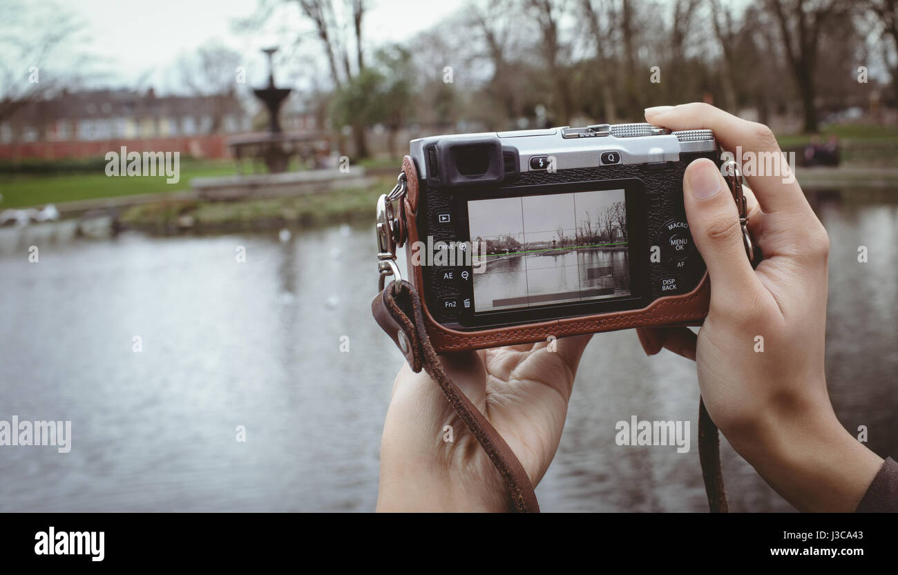 Woman taking photo from digital camera in park Stock Photo - Alamy