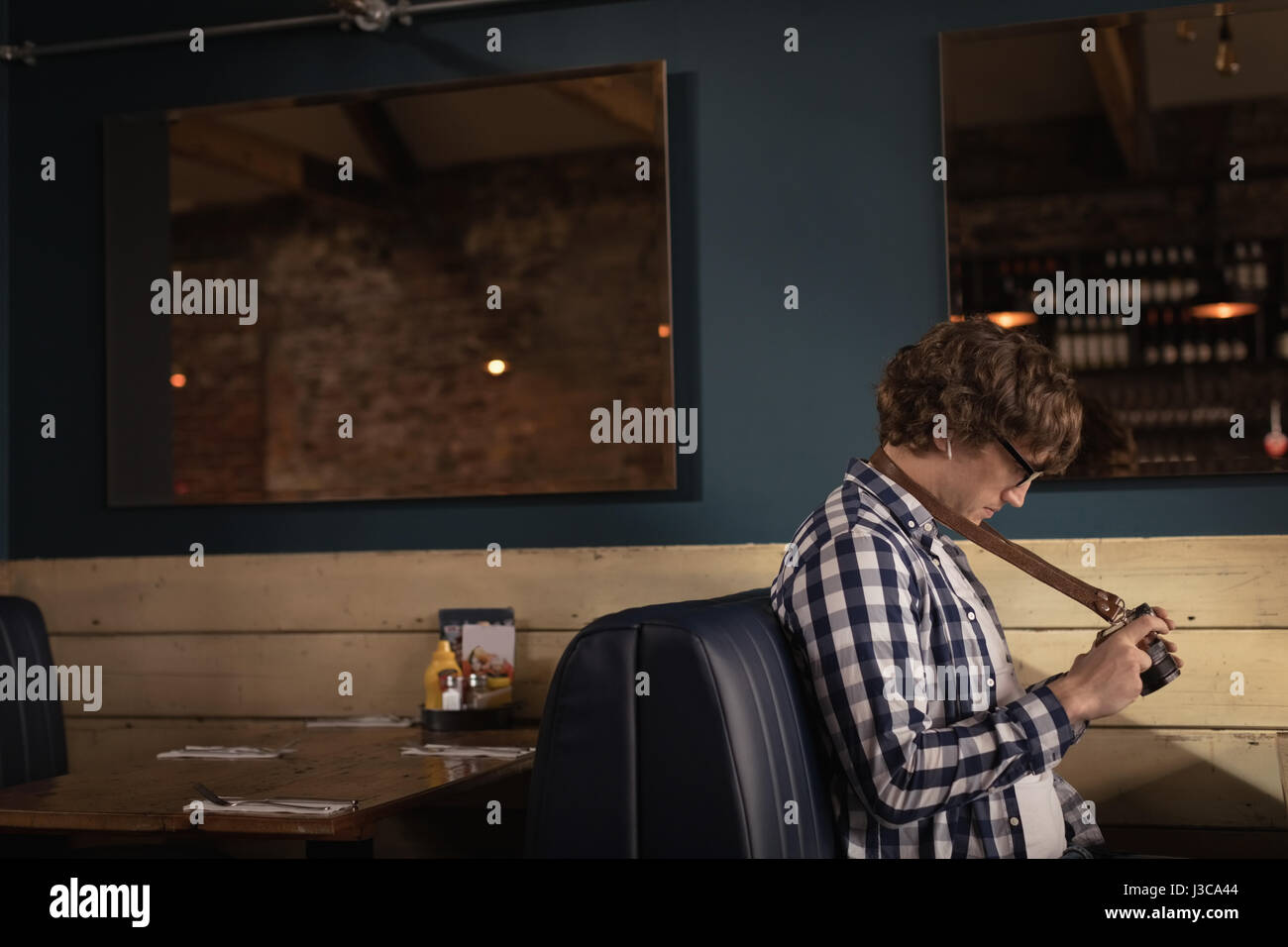 Man looking at digital camera in restaurant Stock Photo - Alamy