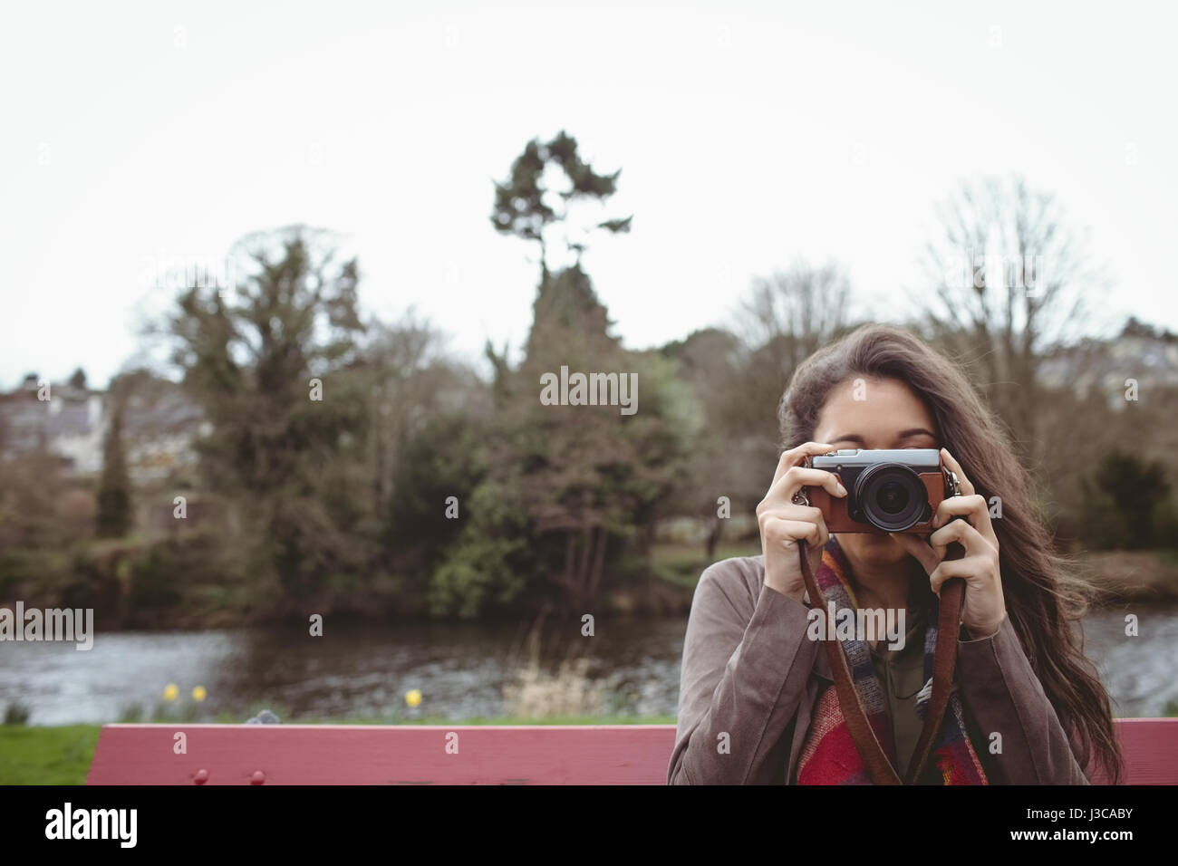 Woman taking photo from digital camera in park Stock Photo - Alamy