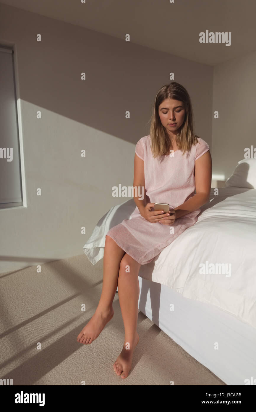 Beautiful woman using mobile phone in bedroom at home Stock Photo - Alamy