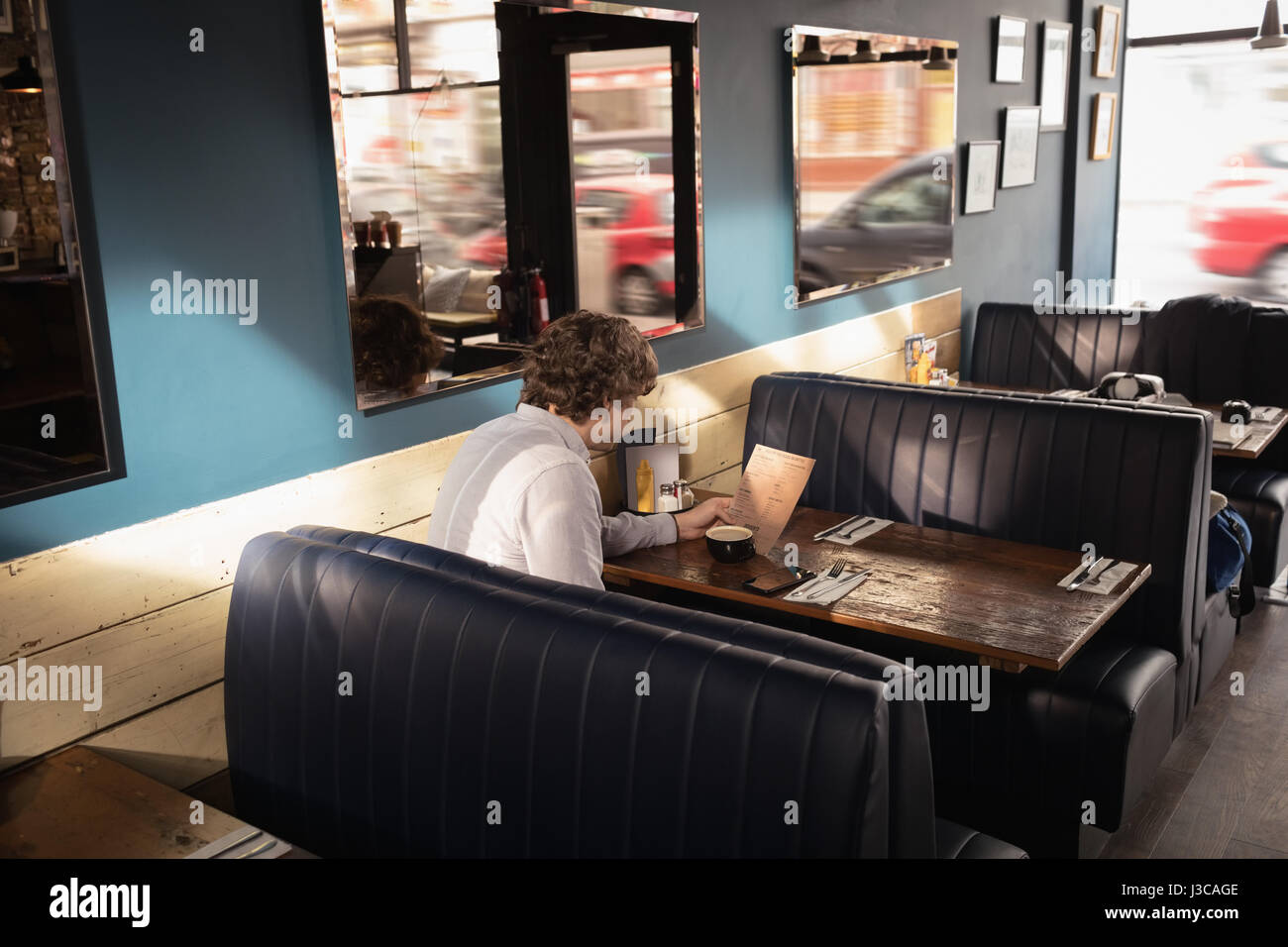 Man looking at menu card in restaurant Stock Photo - Alamy
