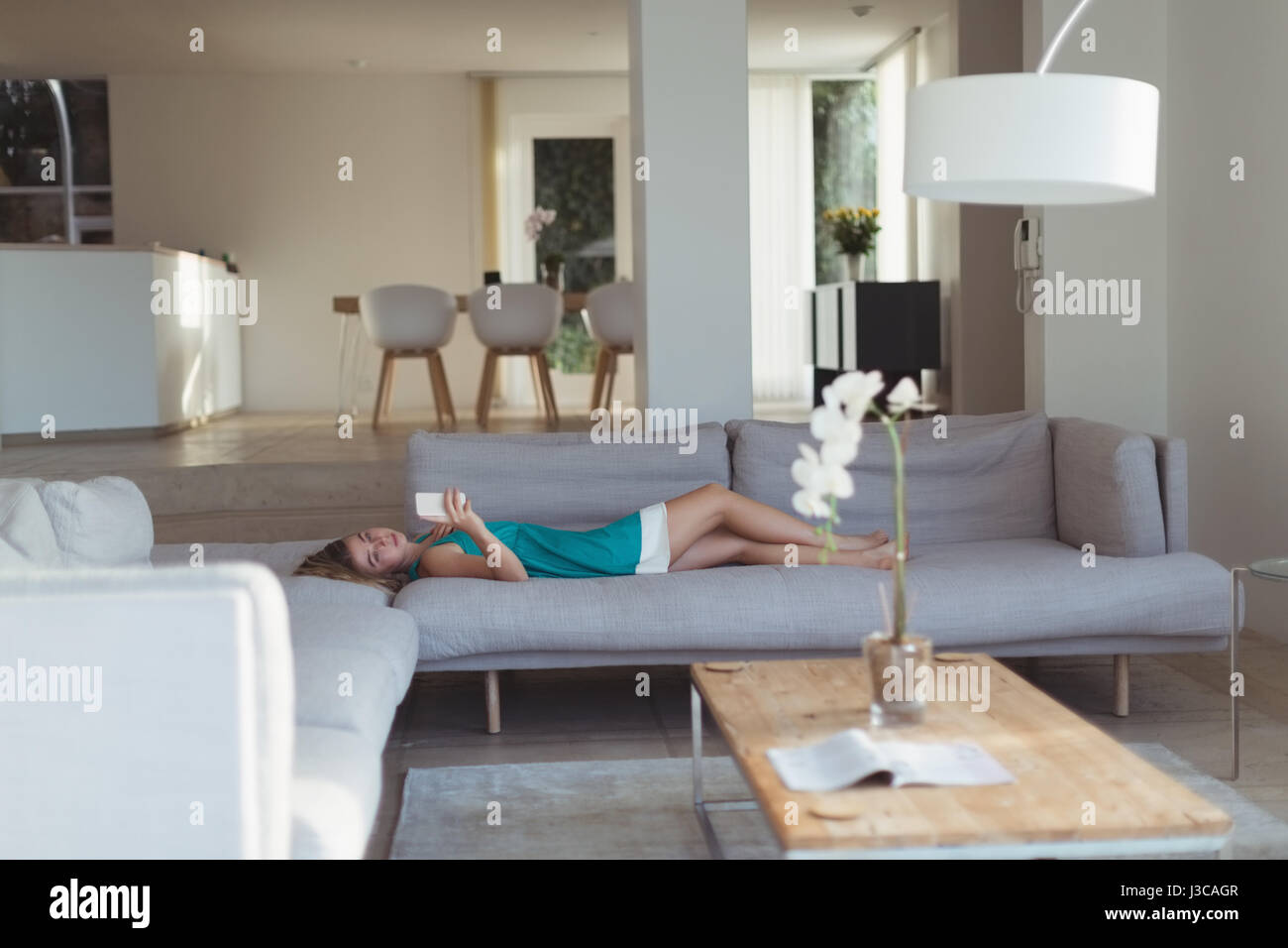 Beautiful woman using mobile phone in living room at home Stock Photo ...