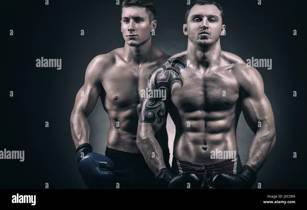 Two young boxer with boxing gloves before a fight on a black background ...