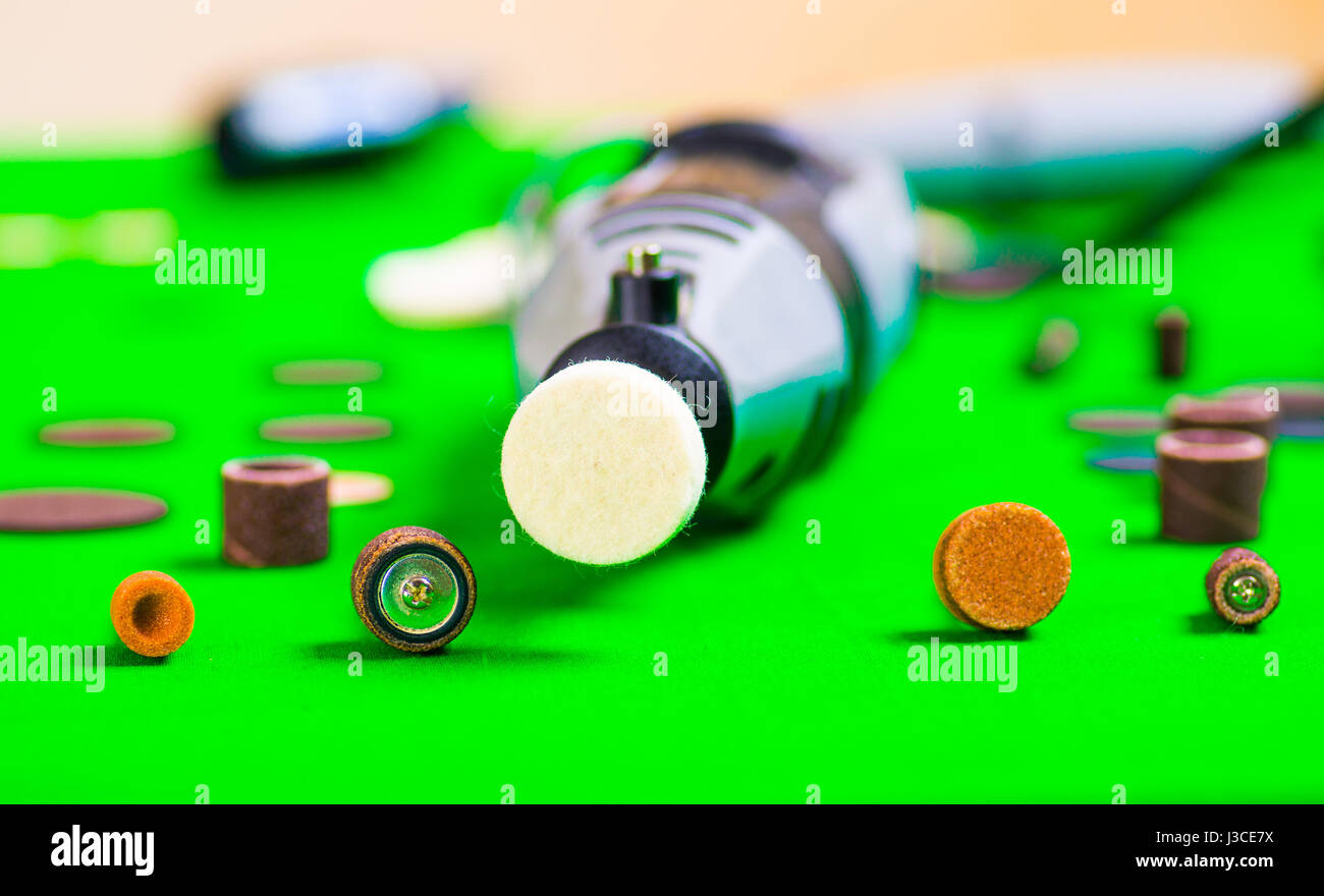 A gray drill with some drilling accessories on green background Stock ...