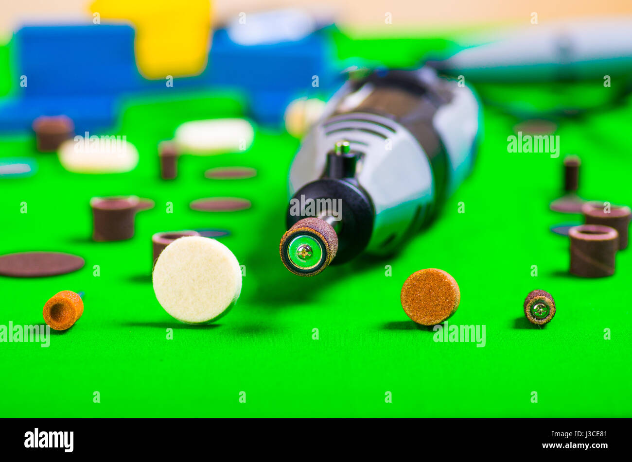 A gray drill with some drilling accessories on green background Stock ...
