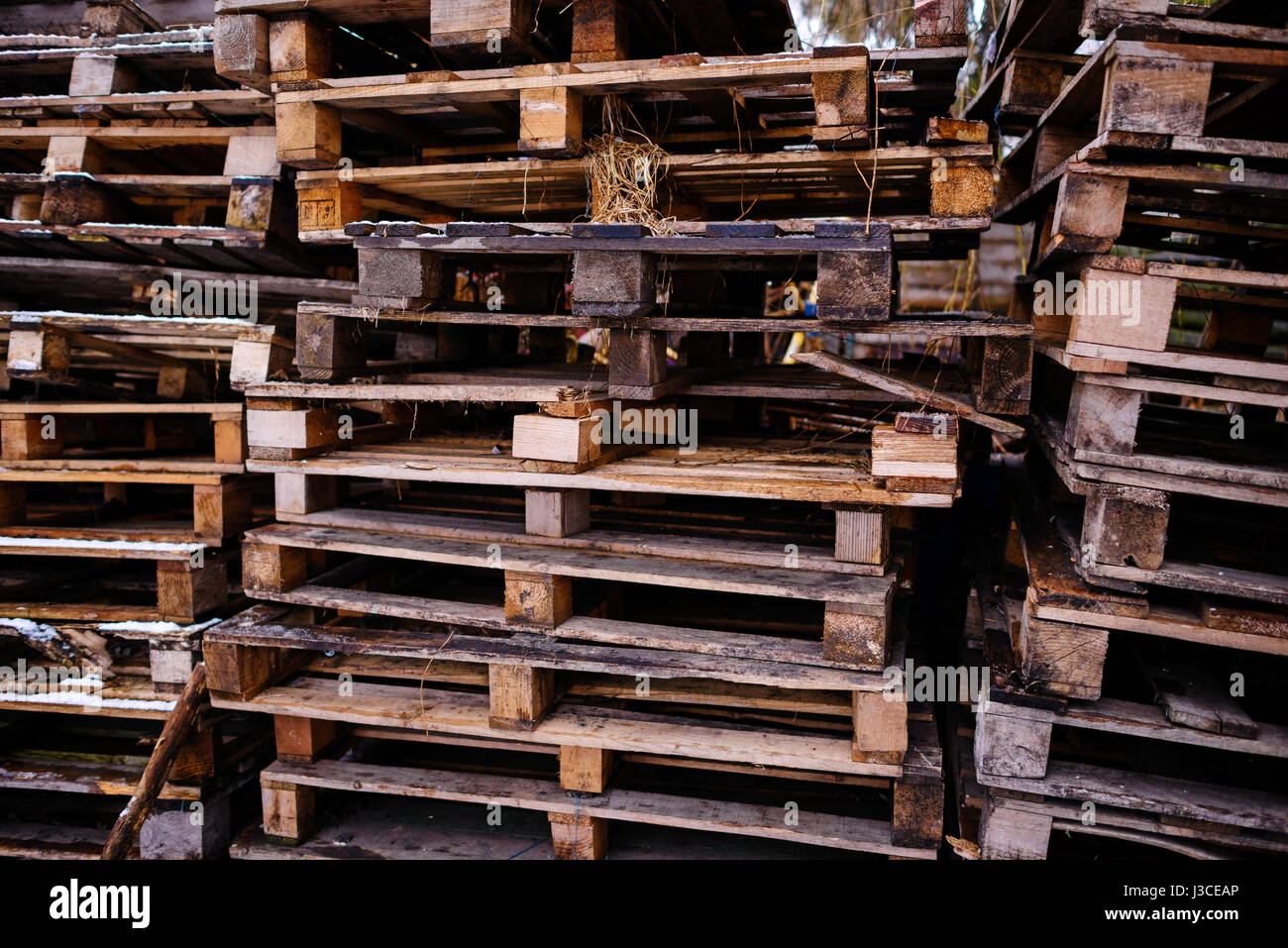 Bunch of old wet colored wooden pallets on green grass Stock Photo - Alamy