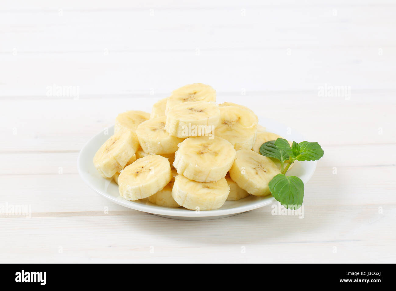 plate of sliced banana on white background Stock Photo - Alamy