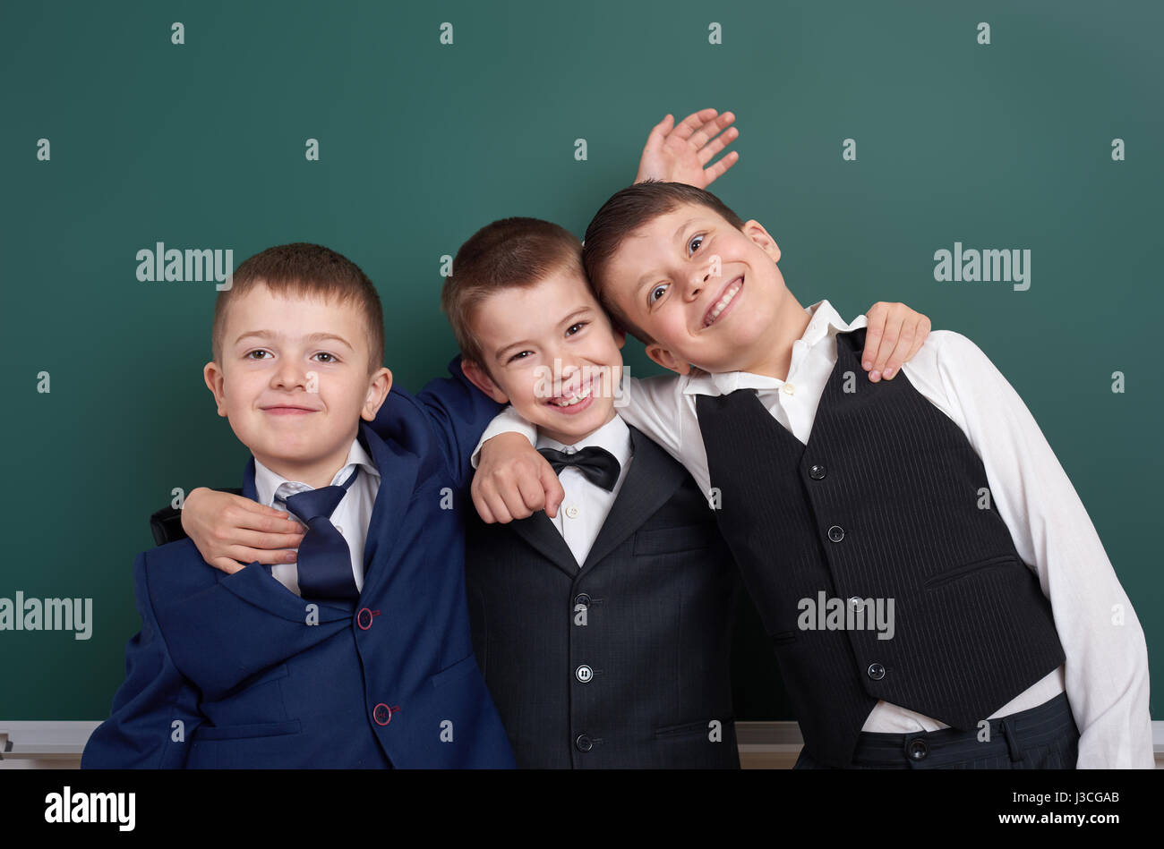 elementary school boy fooling around near blank chalkboard background ...