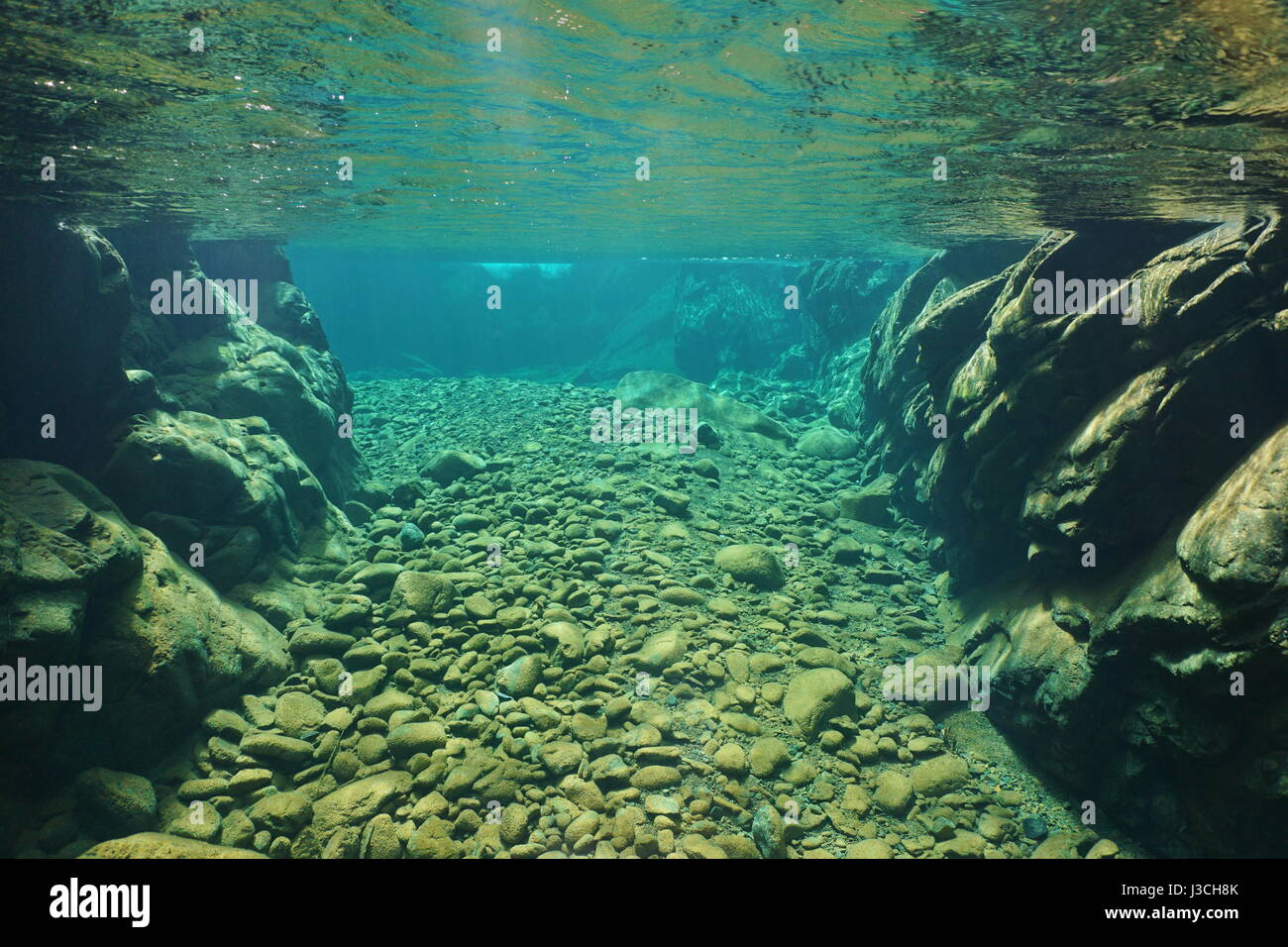 Rocks and pebbles underwater in a river with clear freshwater, Dumbea ...